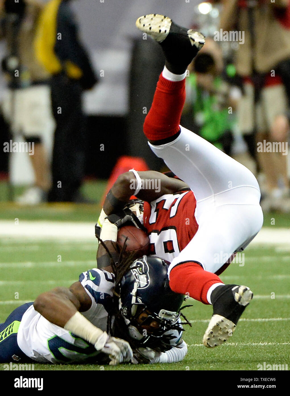 Atlanta Falcons ' Harry Douglas (83) is flipped by Seattle Seahawks ...
