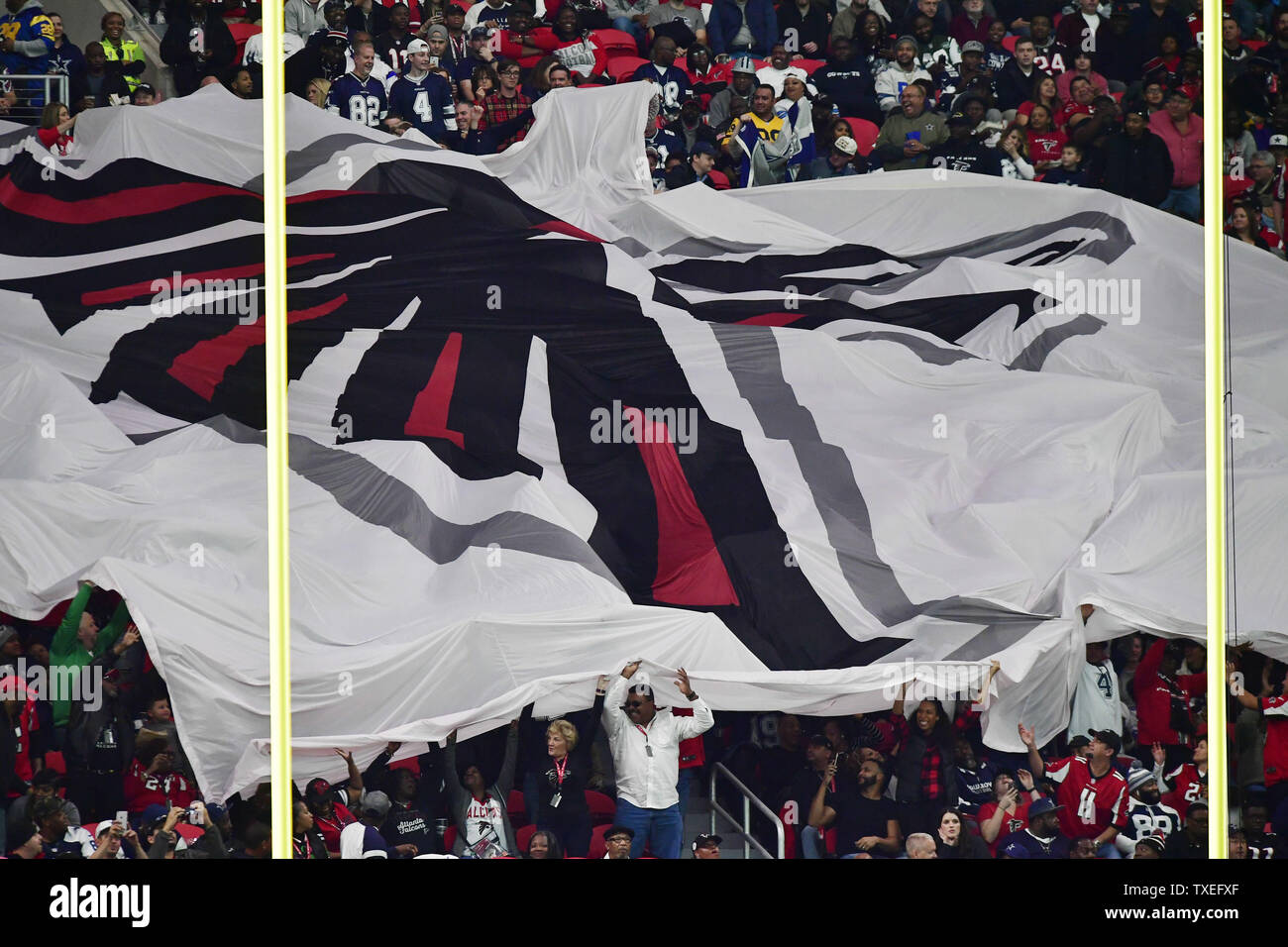 Atlanta Falcons fans carry a flag during the first half of an NFL game ...