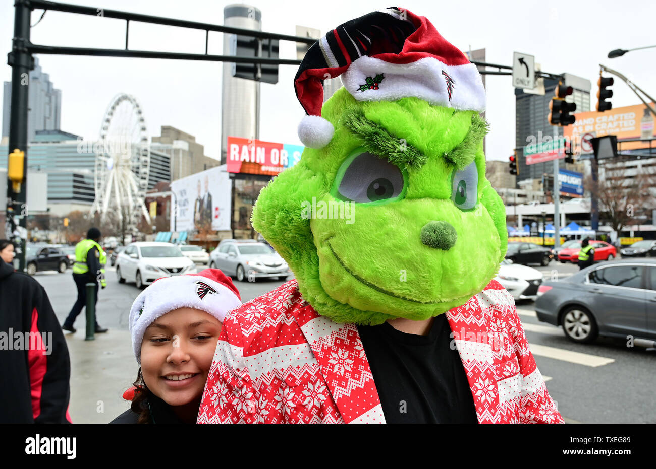 A person dressed as Mr. Grinch walks to Mercedes-Benz Stadium for an ...