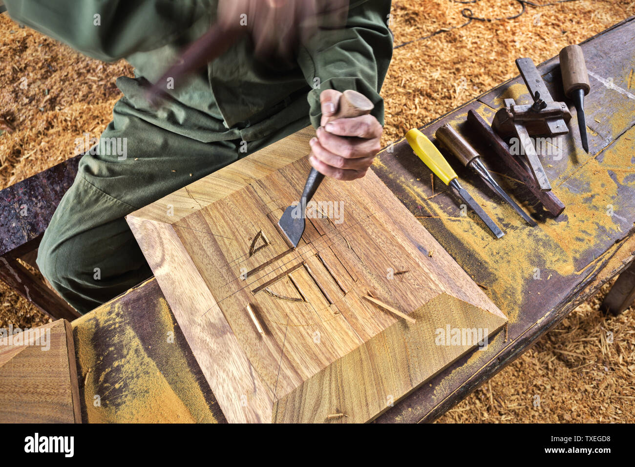 wood chisel carpenter tool hammer in hand working wooden background ...