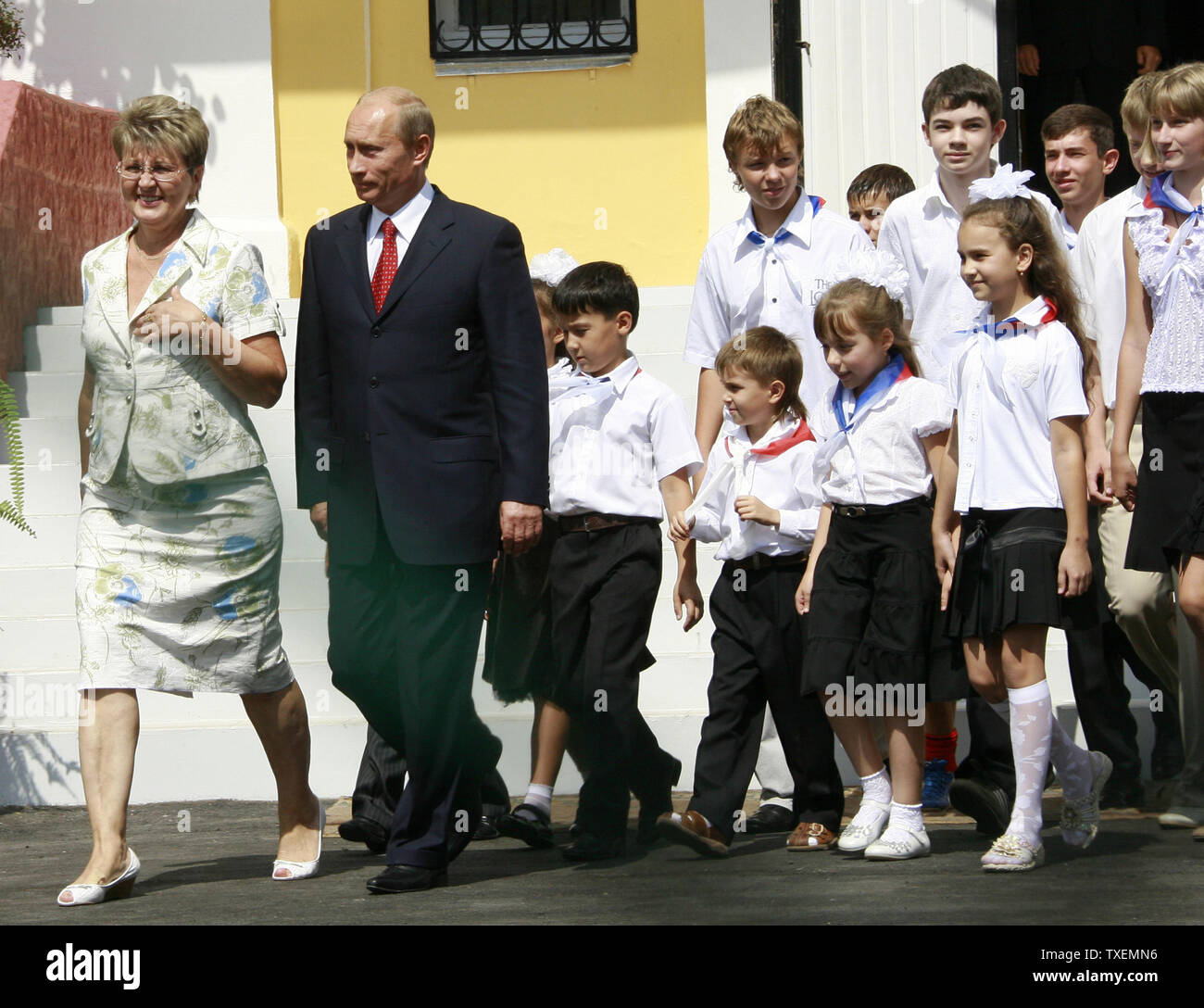 Russian President Vladimir Putin walks out with students as he visits a ...