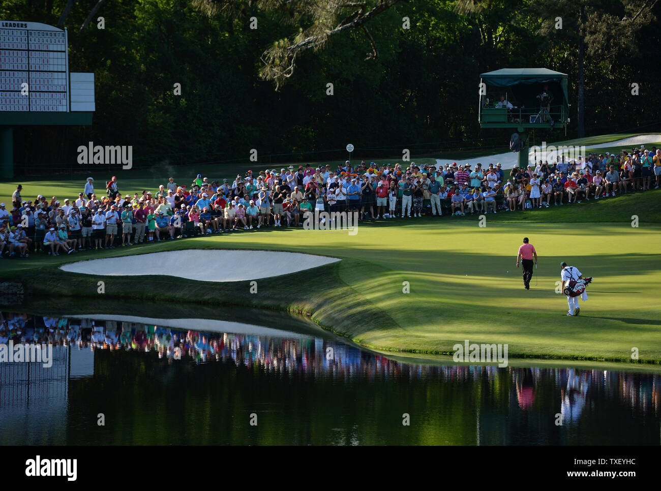 Patrons react as Phil Mickelson walks on to the 16th green in the third ...