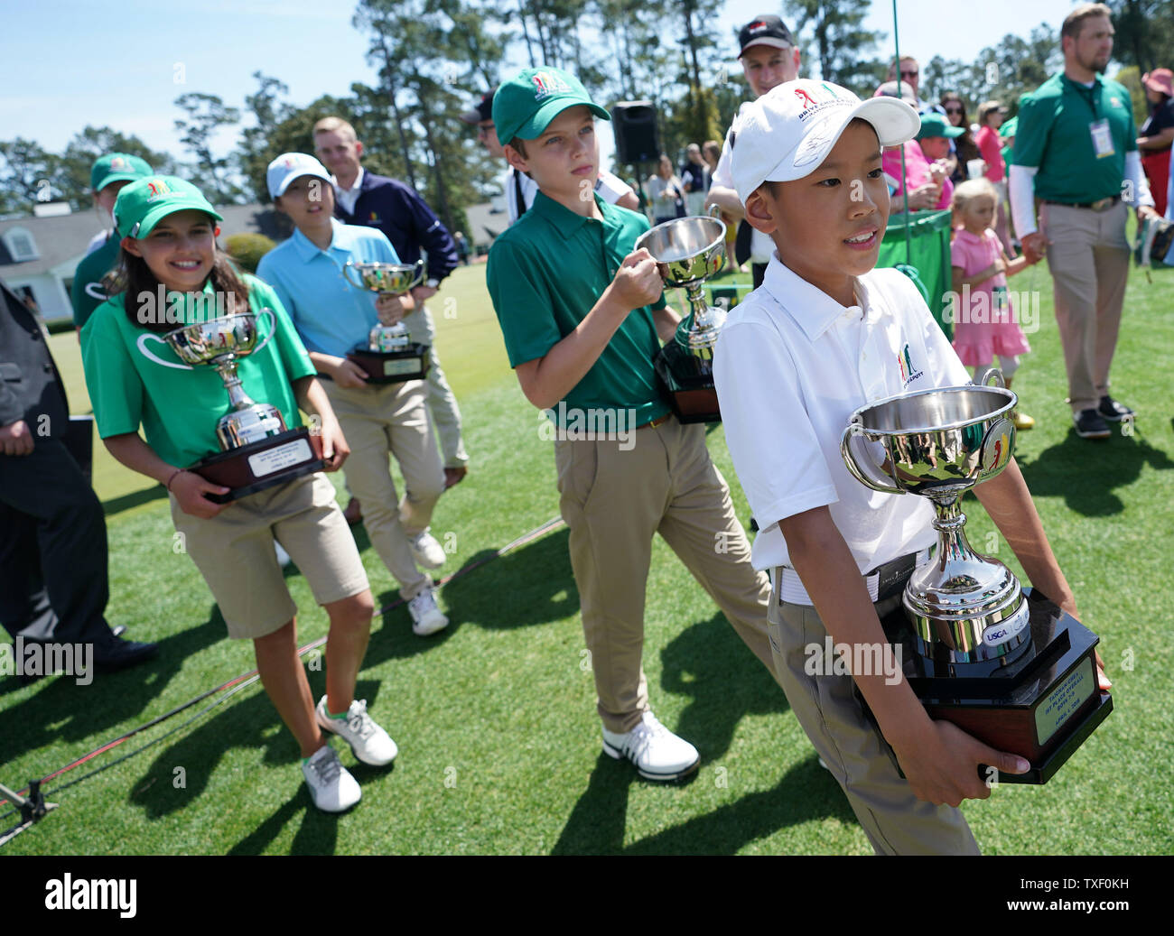 Winners in the Drive Chip & Putt National Finals carry their trophies ...