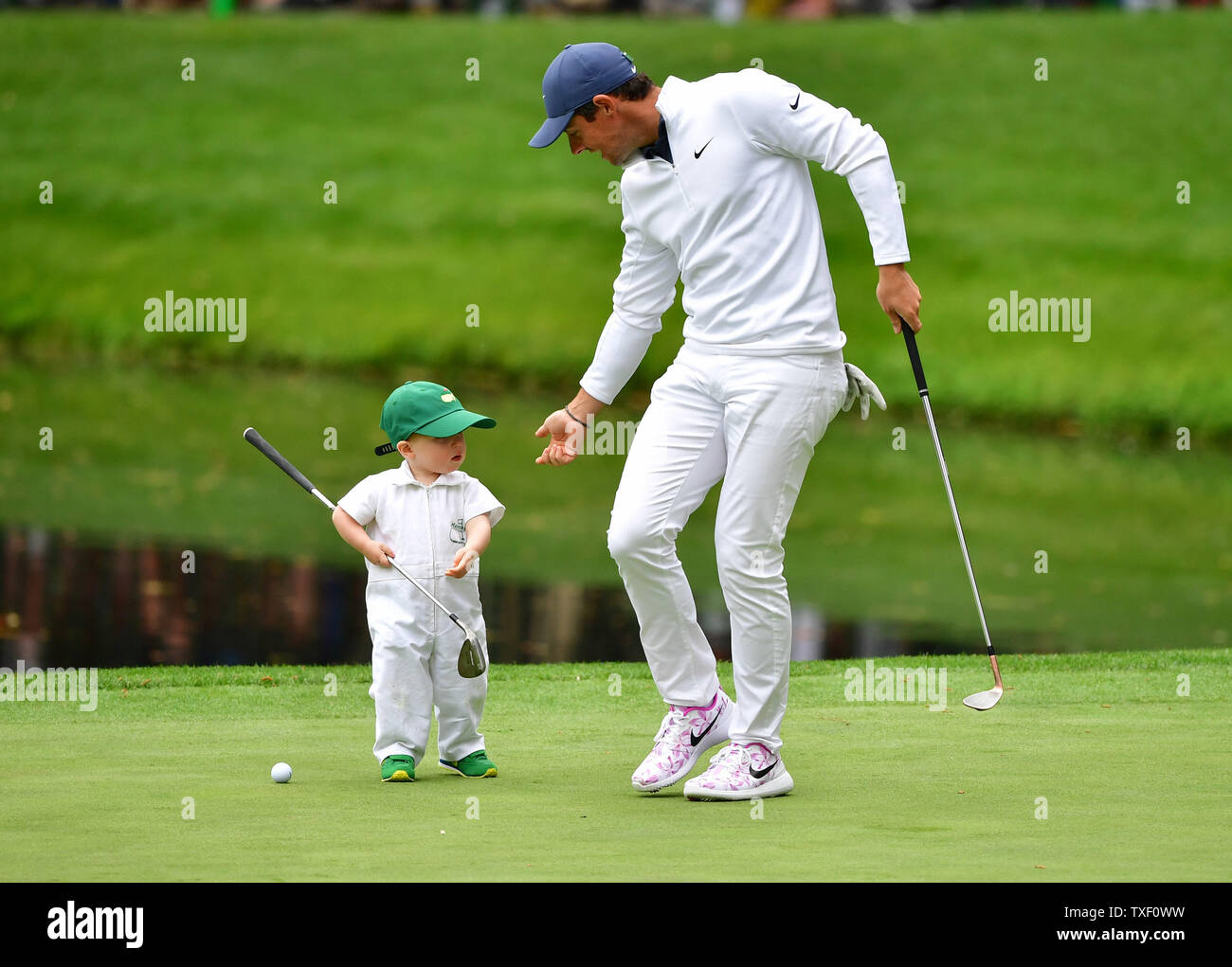 Rory McIlroy greets Ted Potter Jr.'s son Corbin, on the ninth green ...