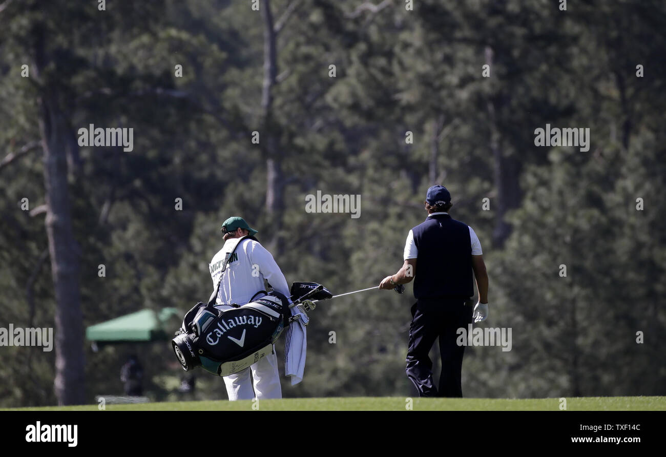 Phil Mickelson walks with caddie Tim Mickelson after hitting an iron on ...