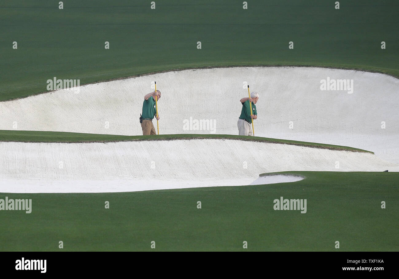 Workers rake a sand trap on the Monday before the 2019 Masters ...