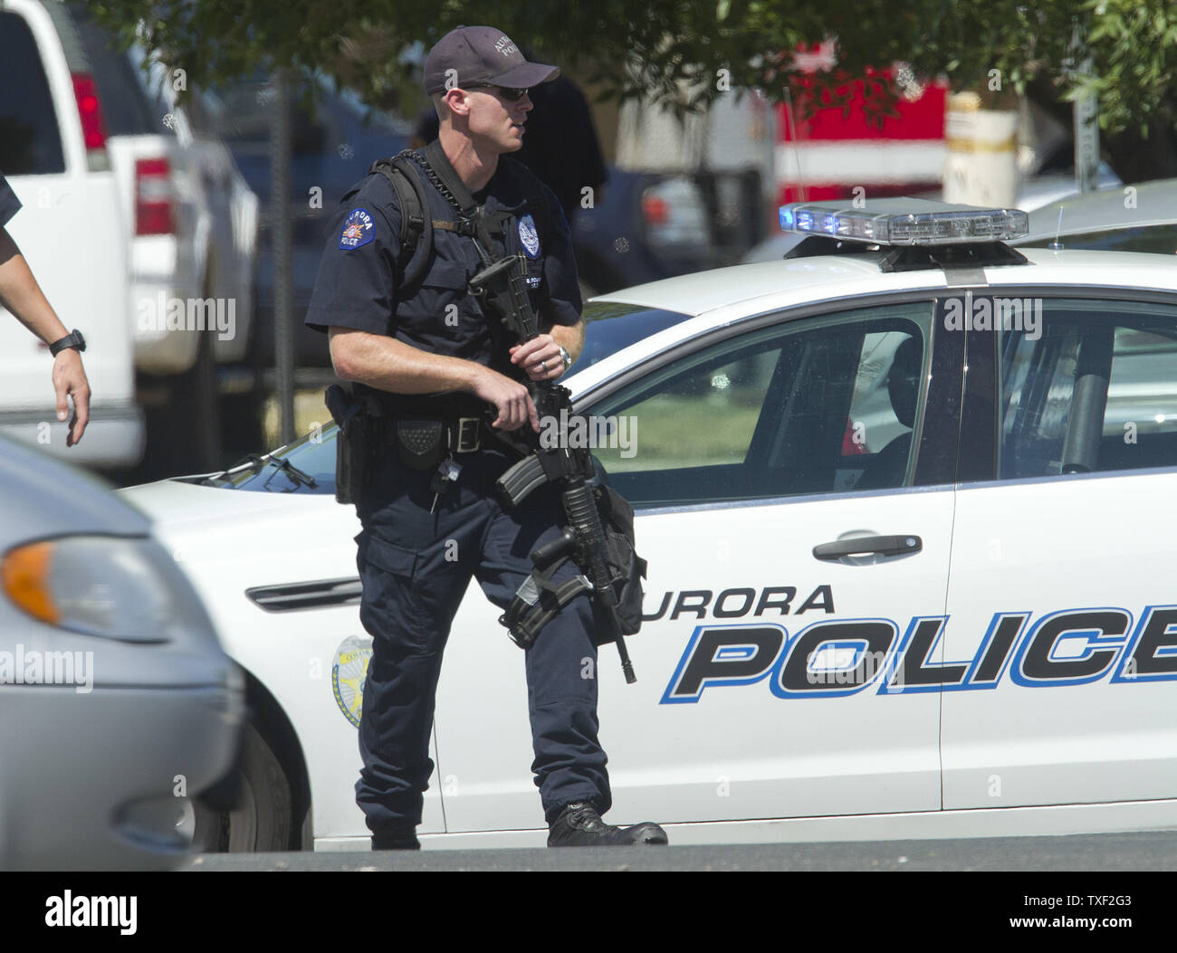 Armed officers stand watch after twelve movie goers were shot and ...