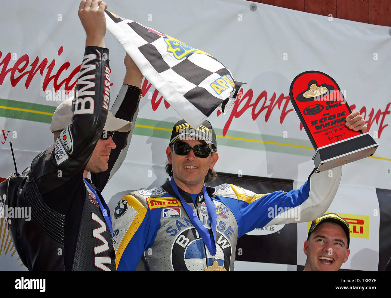 Brian Parriott (R) holds the first place trophy and fellow rider of the ...