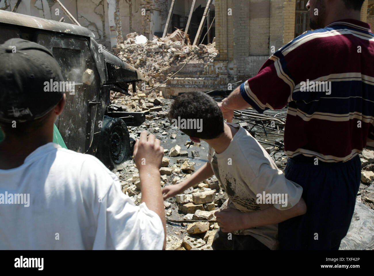 Iraqis loot and throw stones at U.S. humvees after a road side bomb ...