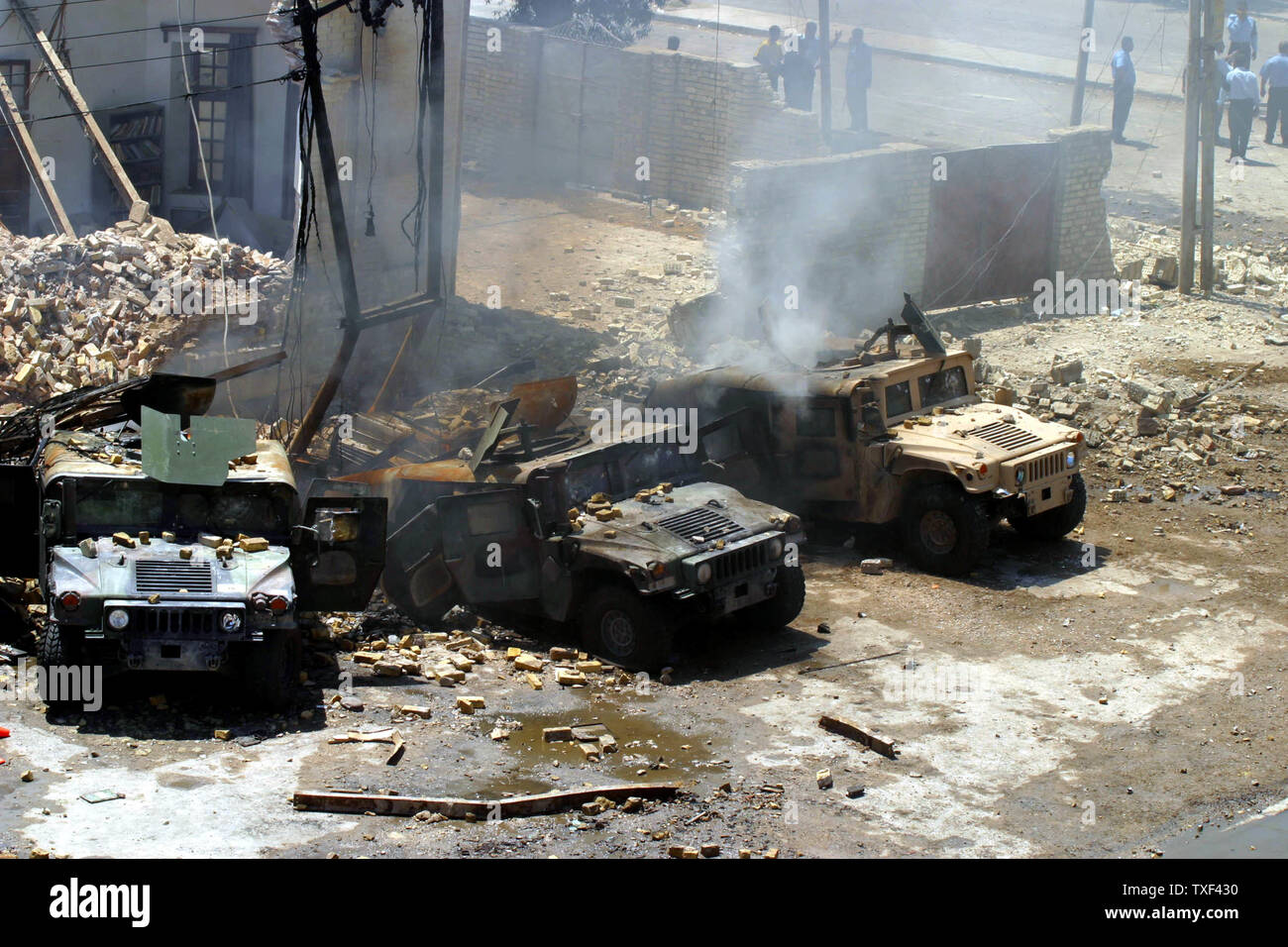 Iraqis loot and throw stones at U.S. humvees after a road side bomb ...