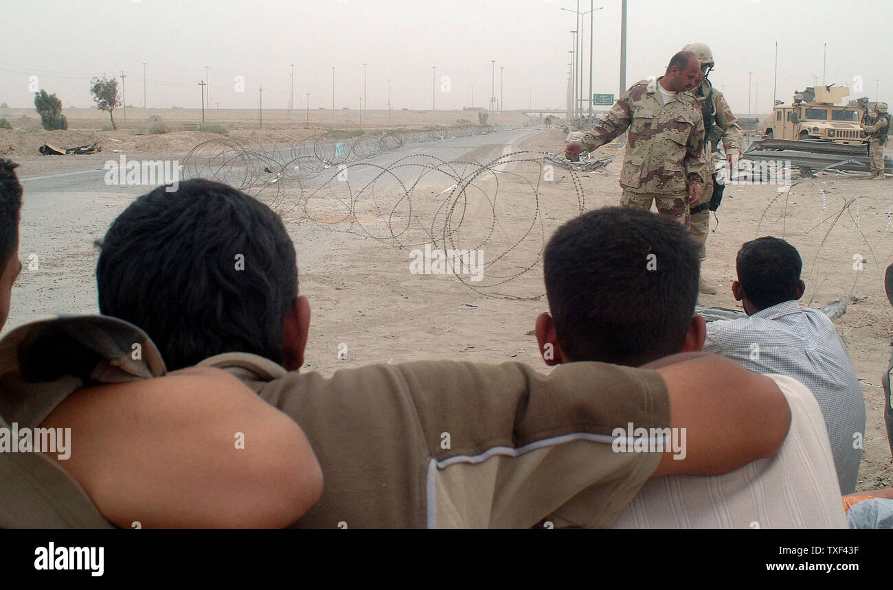 Iraqis wait at a checkpoint outside Fallujah, Iraq on April 29, 2004 ...
