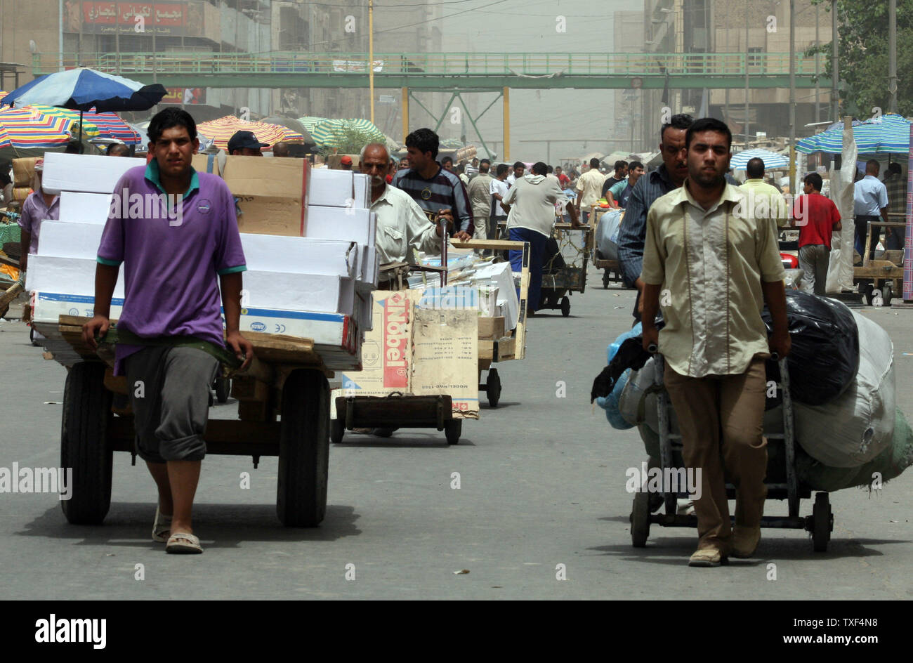 Iraqi porters pull goods on carts at the Sharjah Soukh, in the center ...