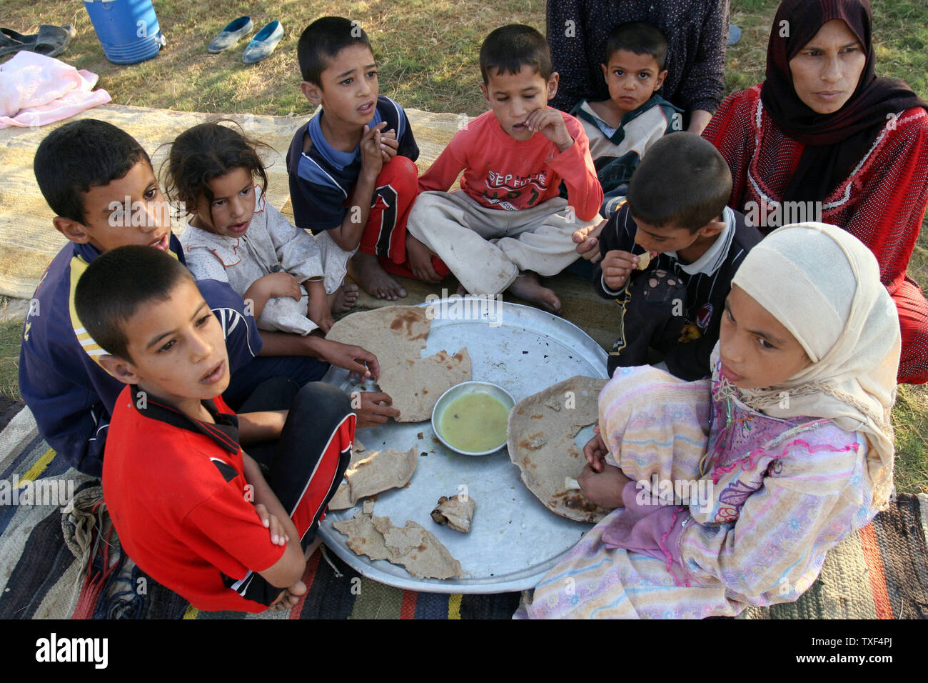 An Iraqi family eats a meal outside their home in the Sunni town of ...
