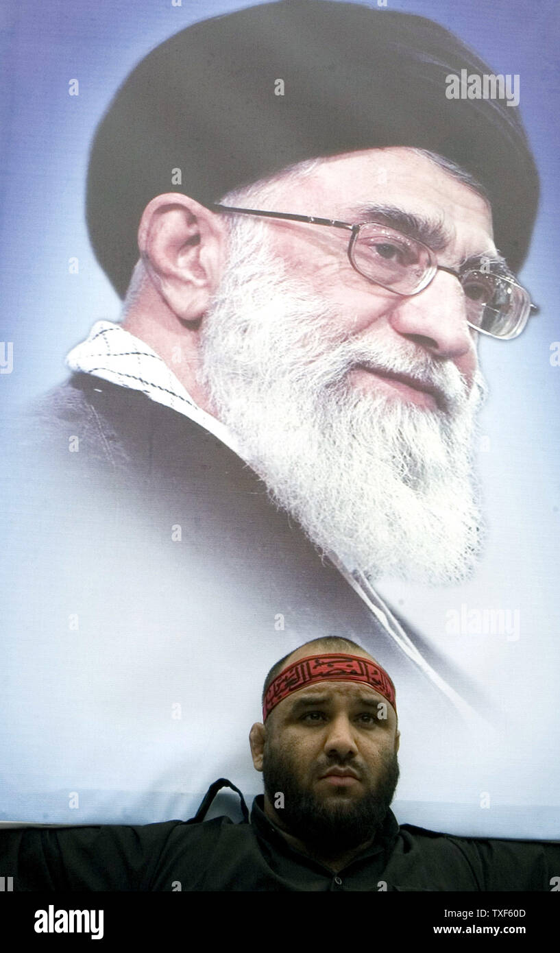 An Iranian Basiji man stands by a picture of Iran's supreme leader ...
