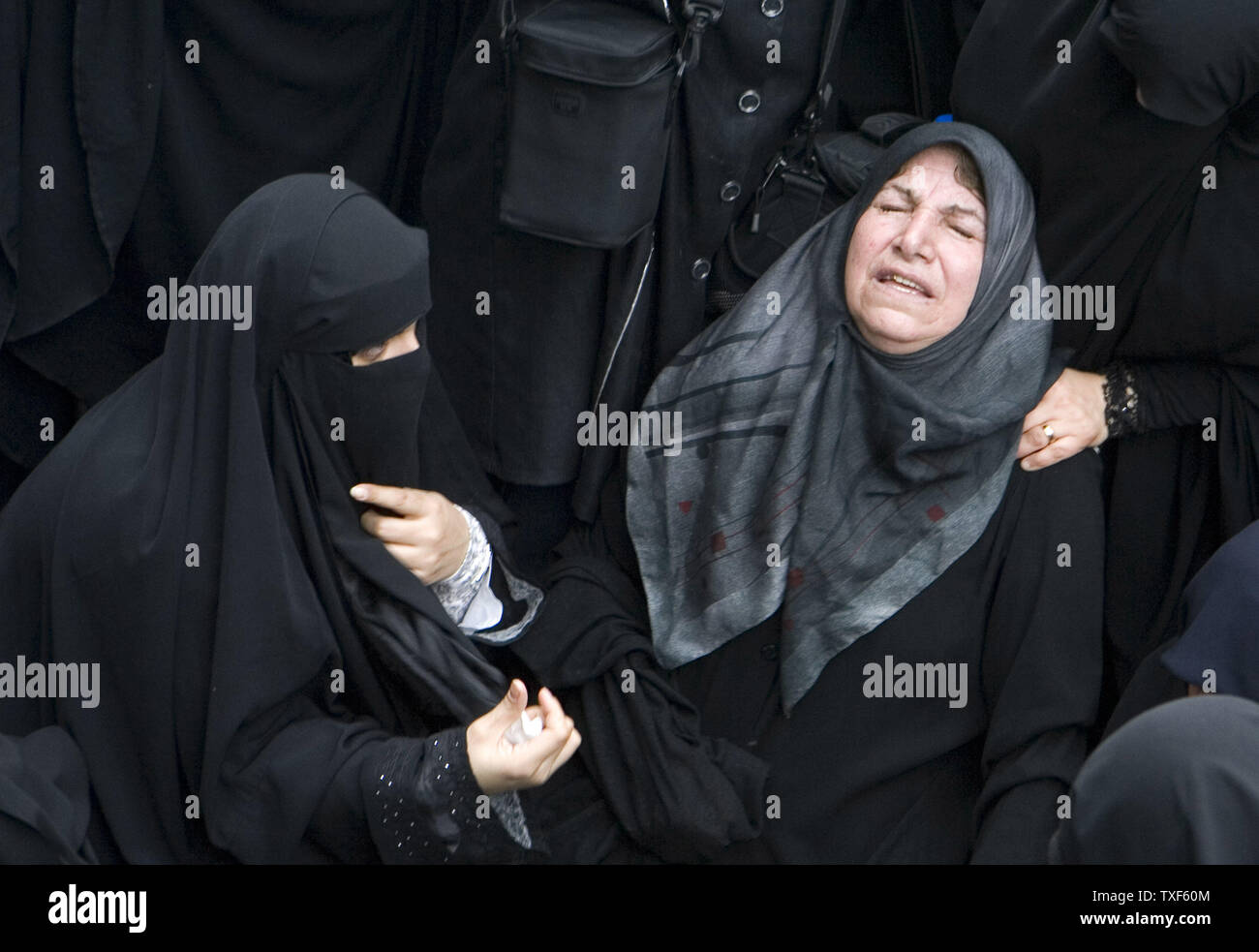 Iranian women cry doing a ceremony to commemorate those who were killed ...