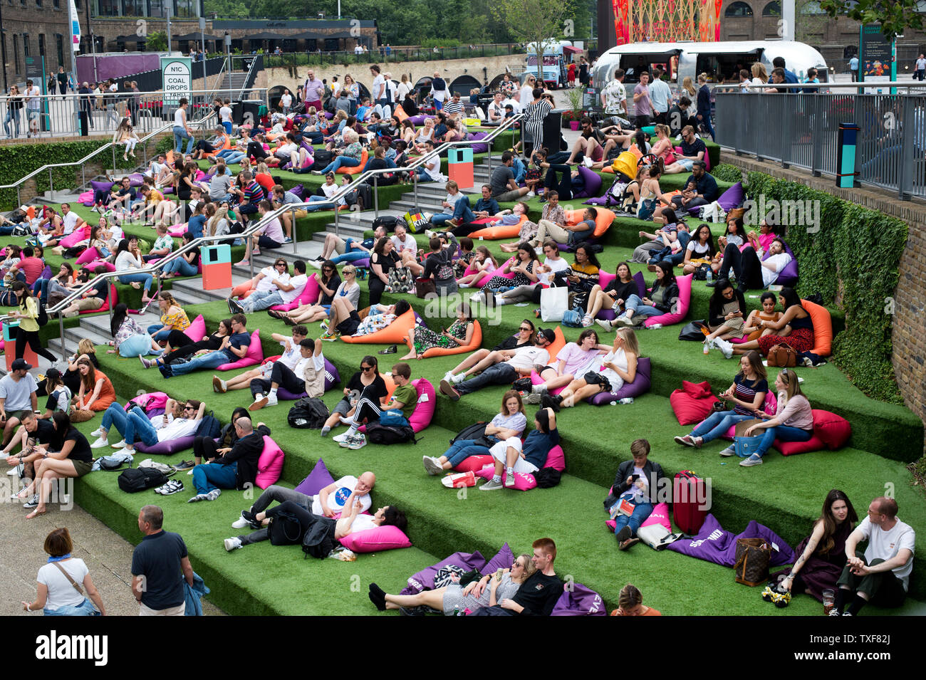 London, Kings Cross. Granary Square. People relax on artificial grass ...