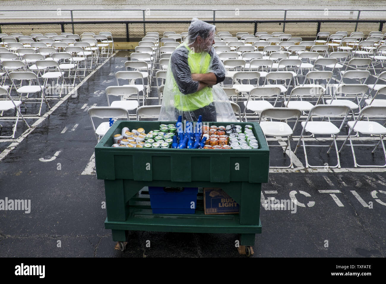 A beer vendor waits in a light rain for customers at the 141st running ...