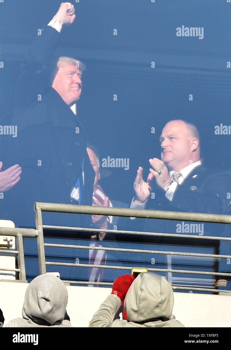 President-elect Donald Trump clinches his fist from the Navy stands ...