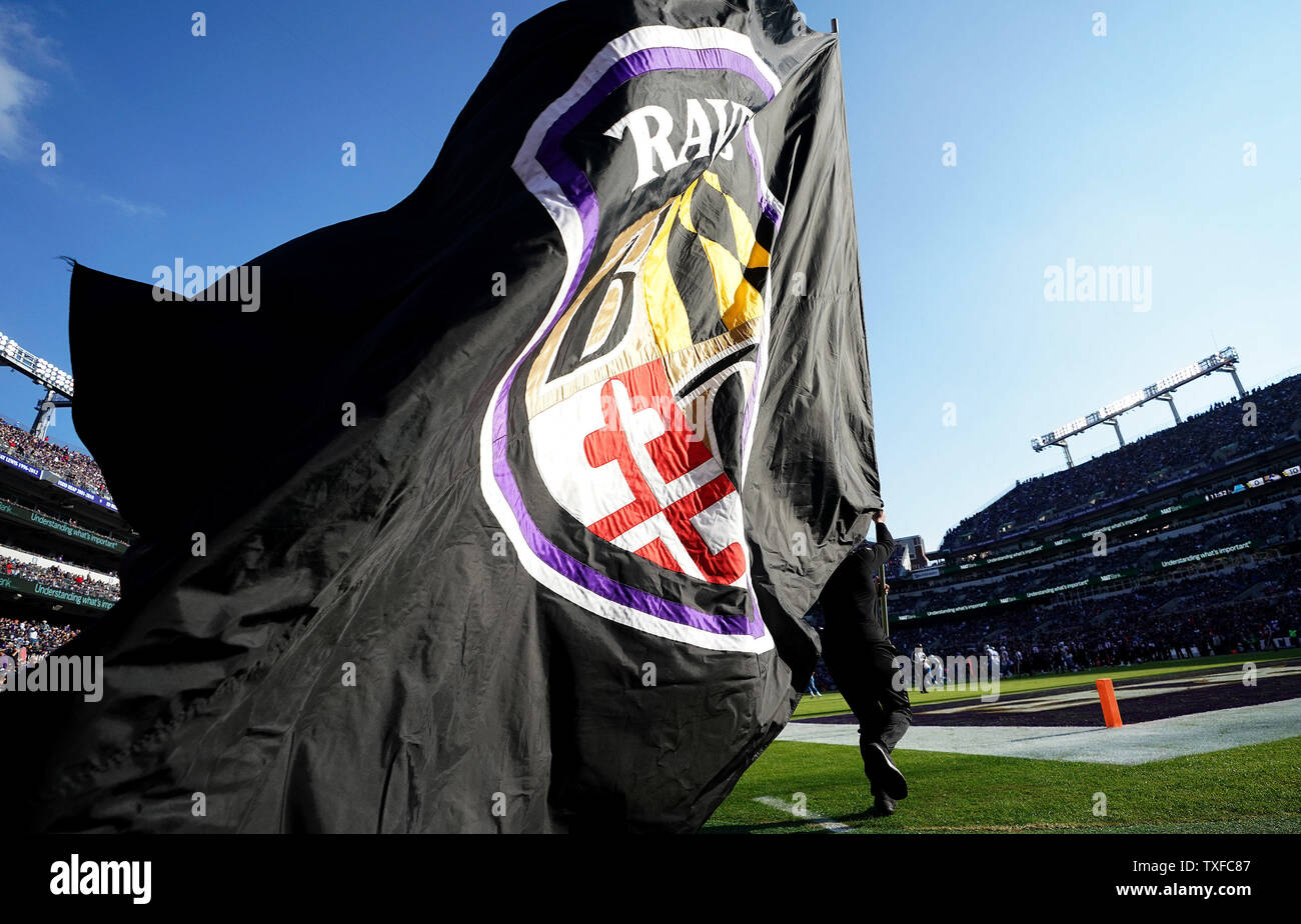 A Baltimore Ravens cheer leader carries a flag onto the field after ...