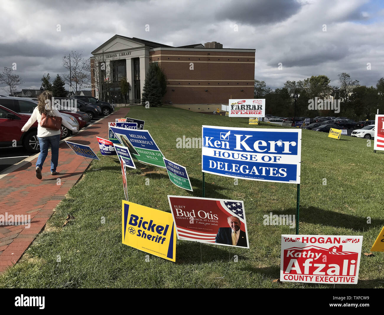 A resident walks past political signs surrounding a library polling ...