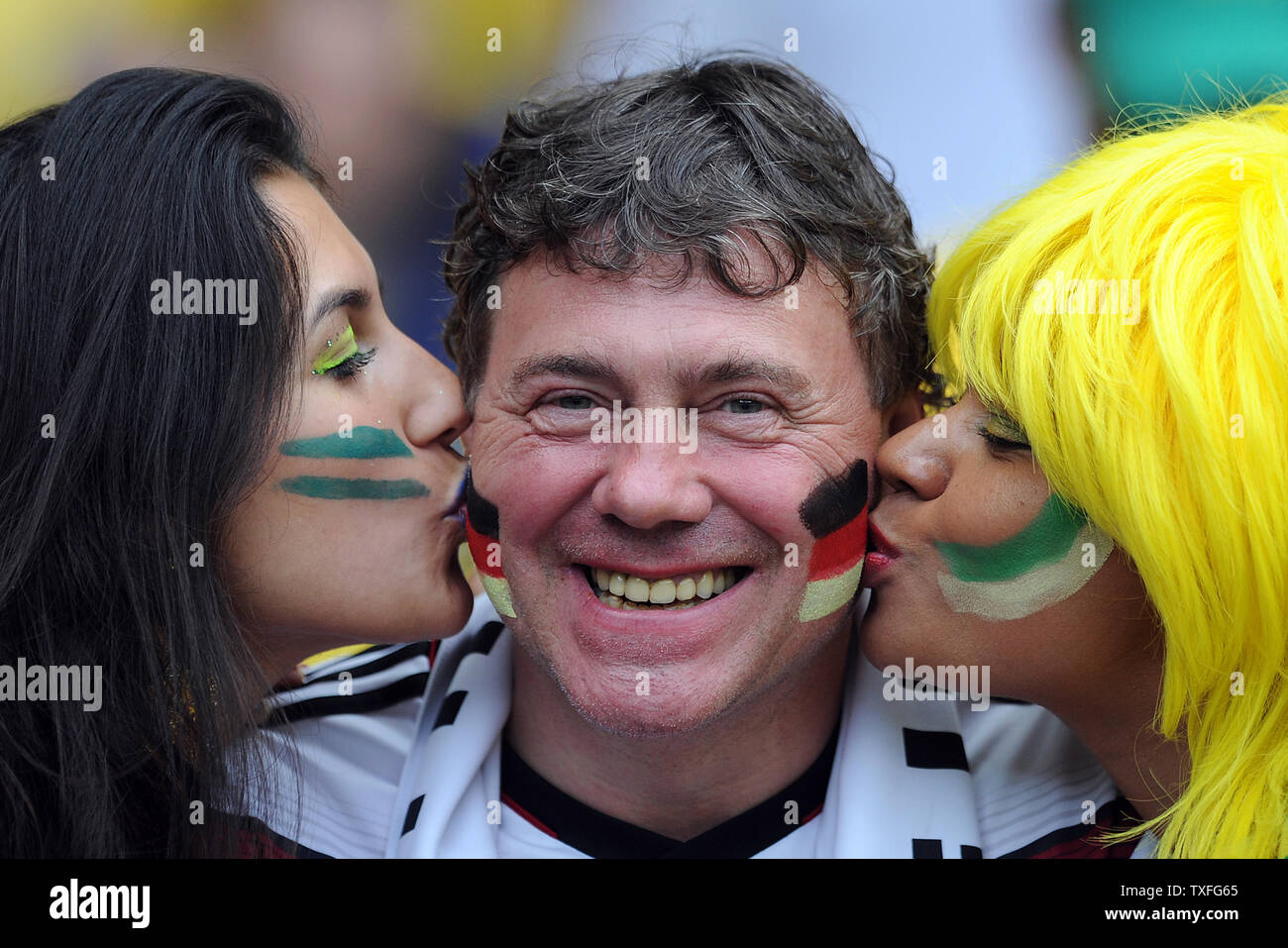A Germany fan receives kisses from Brazil fans prior to the 2014 FIFA ...