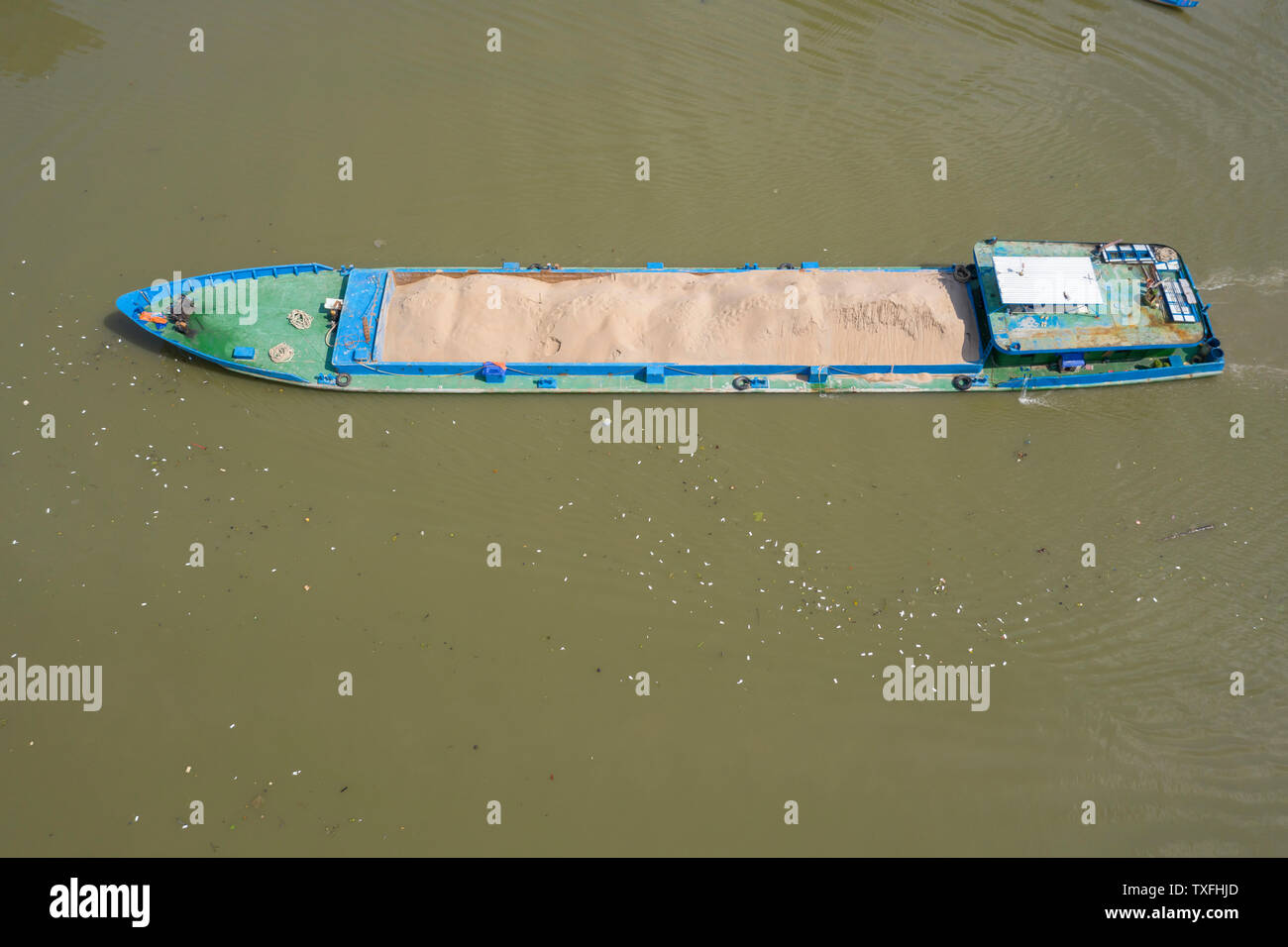 Barges carrying building materials along the busy canal separating ...