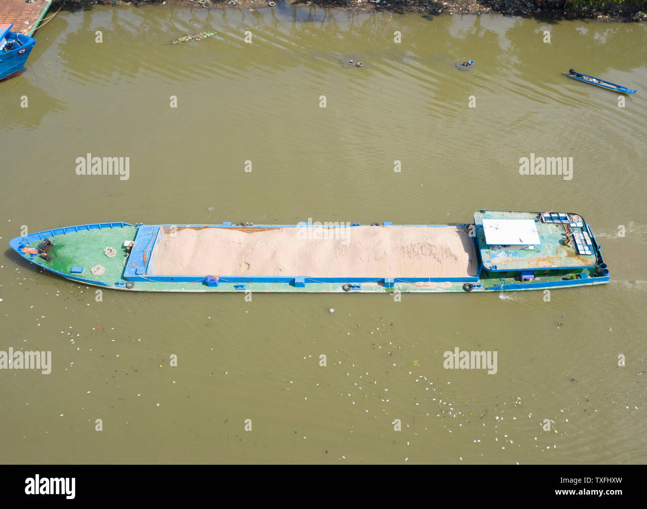 Barges carrying building materials along the busy canal separating ...