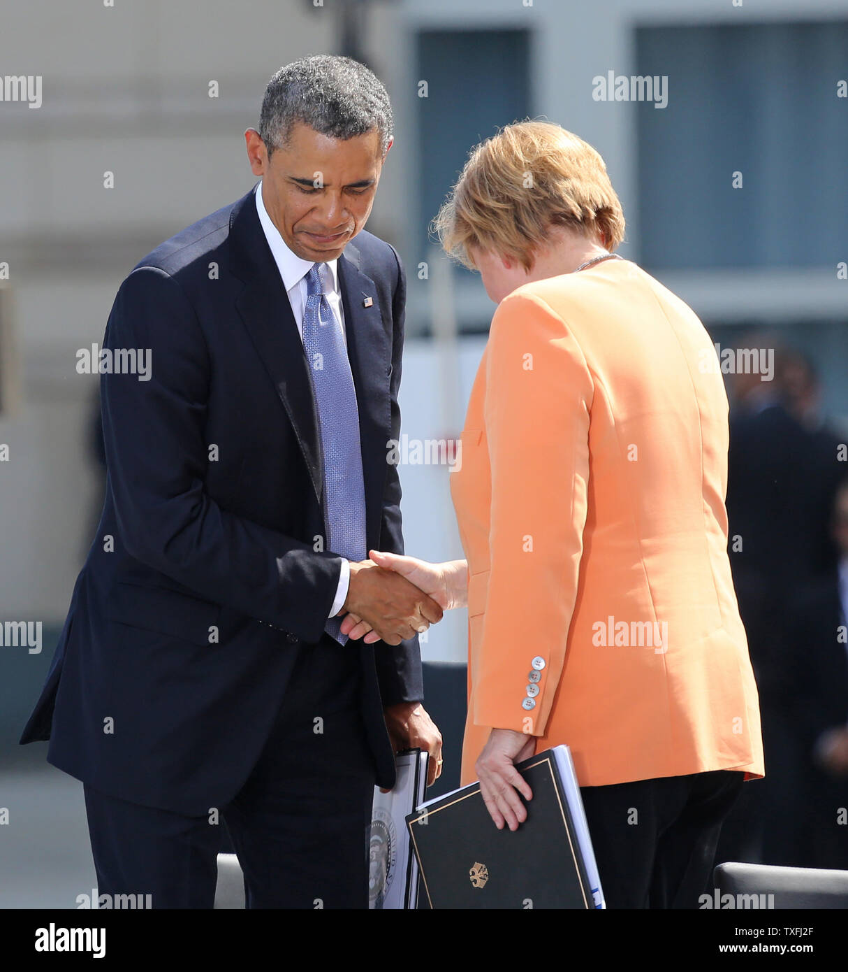 U.S. President Barack Obama shakes the hand of German Chancellor Angela ...