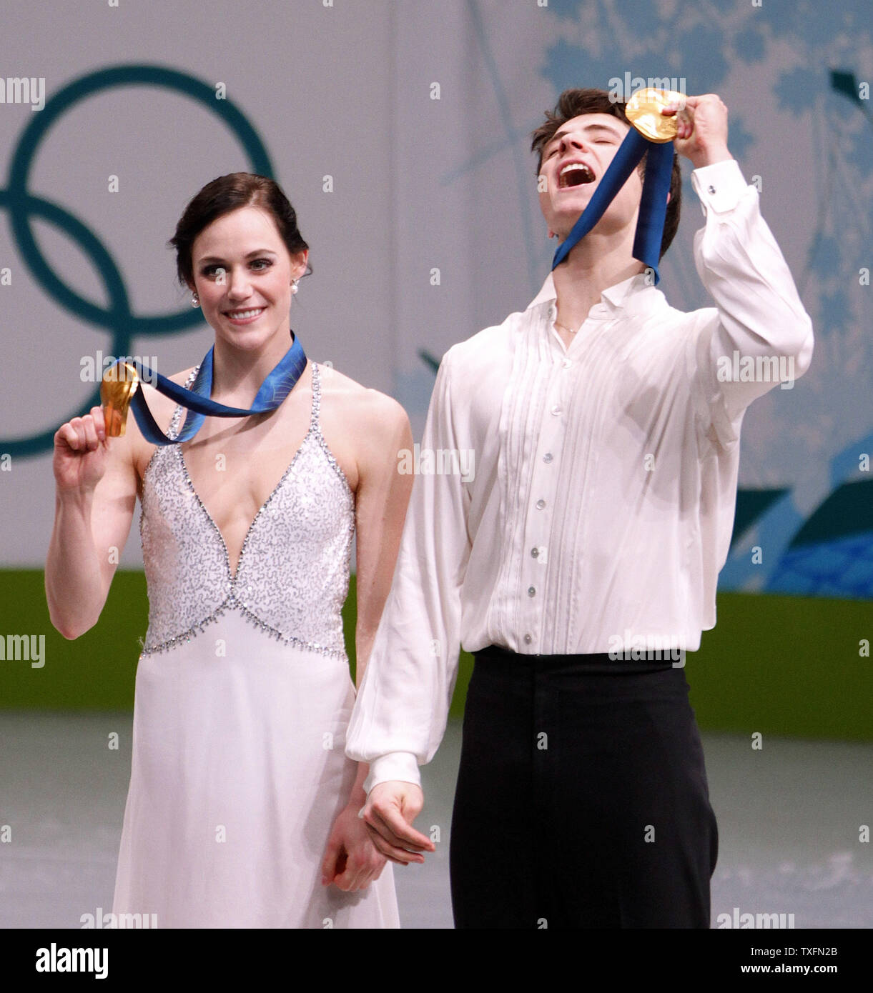 Tessa Virtue (L) and Scott Moir of Canada hold up their gold medals ...
