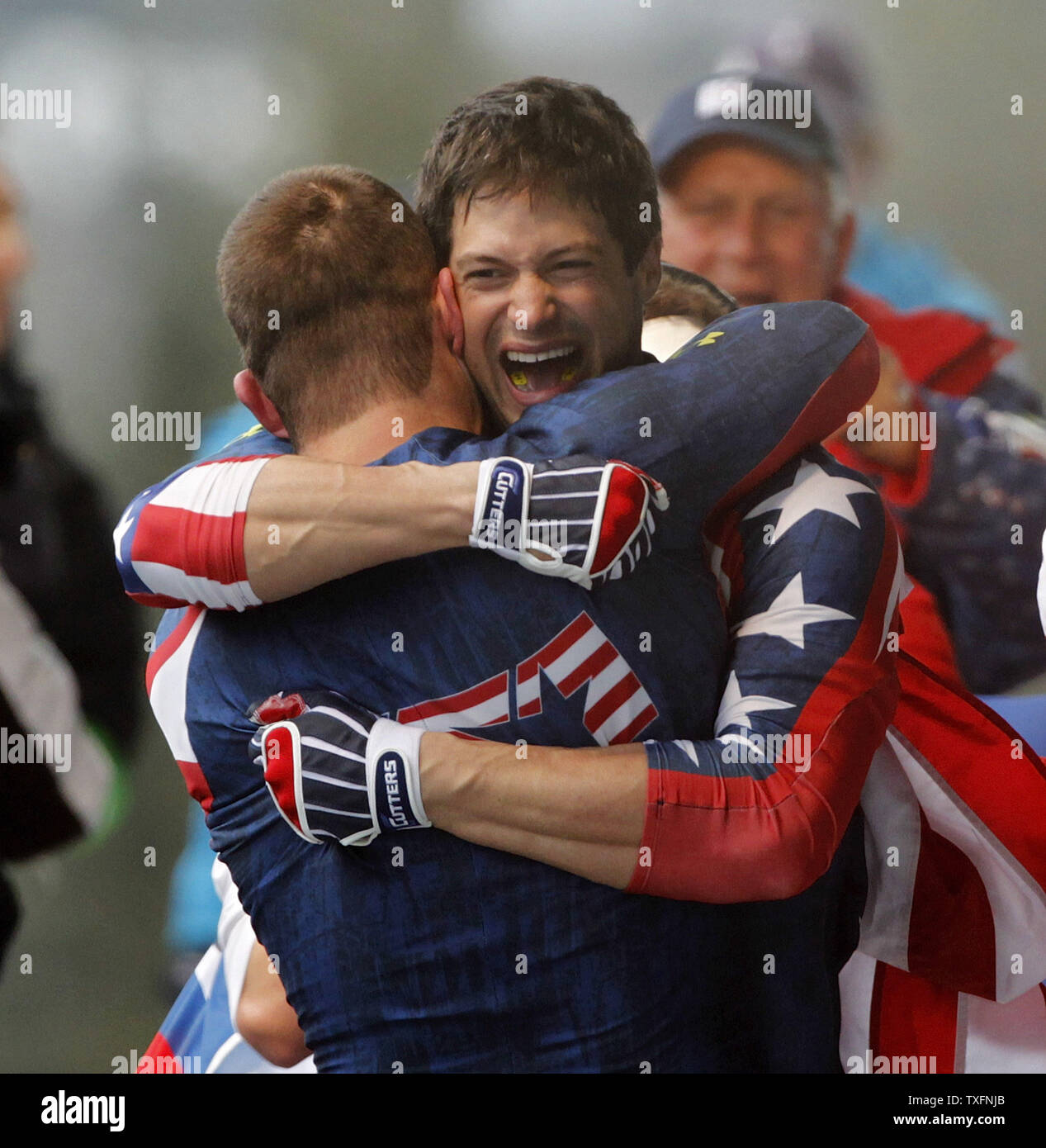 Steve Mesler (R) hugs teammate Justin Olsen after winning a gold medal ...