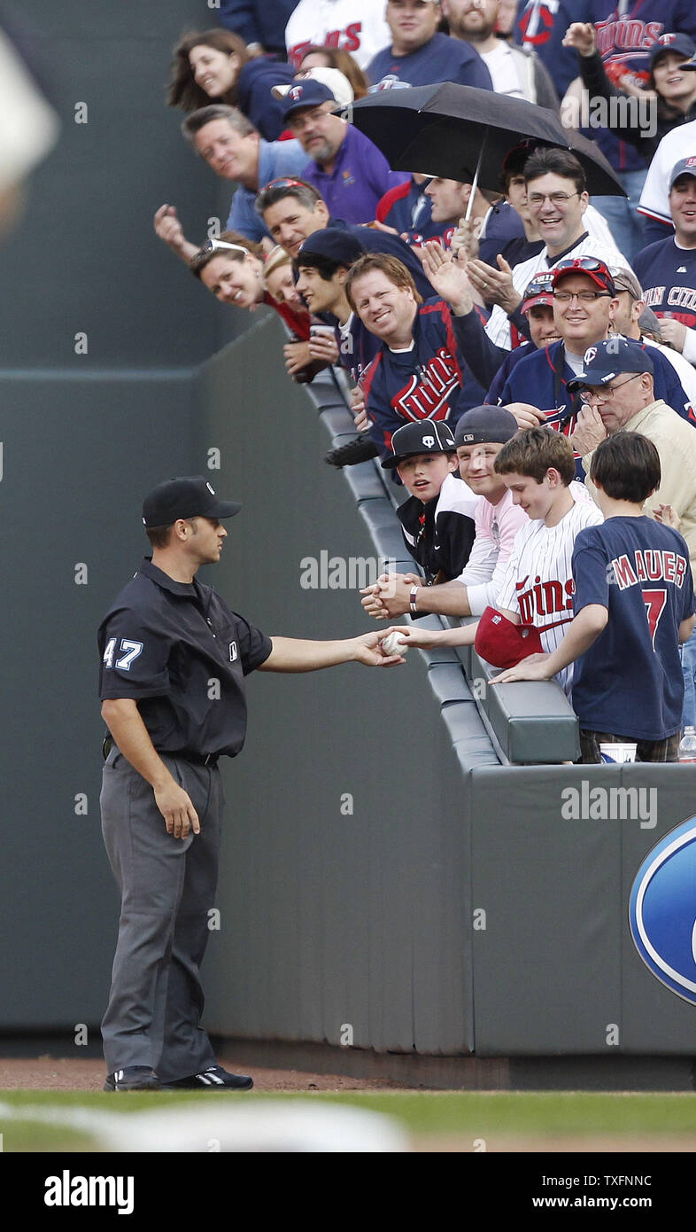 First base umpire Tim Tschida gives a fan a ball on Opening Day at ...
