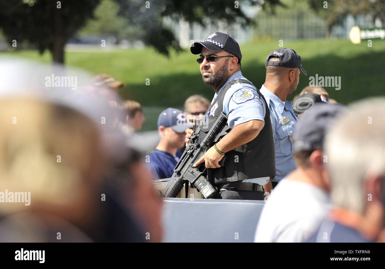 Armed with an assault rifle, a Chicago Police officer watches over the ...