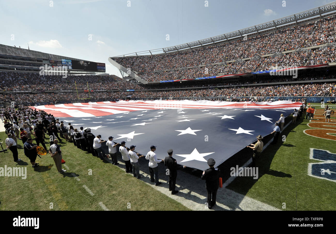 A giant American flag is displayed on the the field during the singing ...