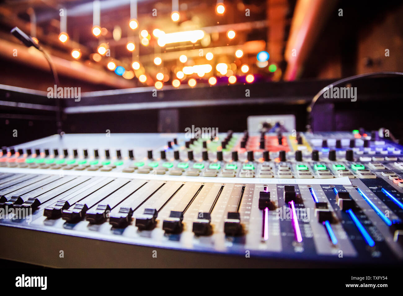 Close up of a professional recording mixer desk, concert with lights in ...