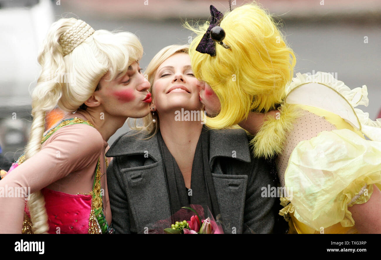 Actress Charlize Theron (C) receives a kiss from Harvard students ...