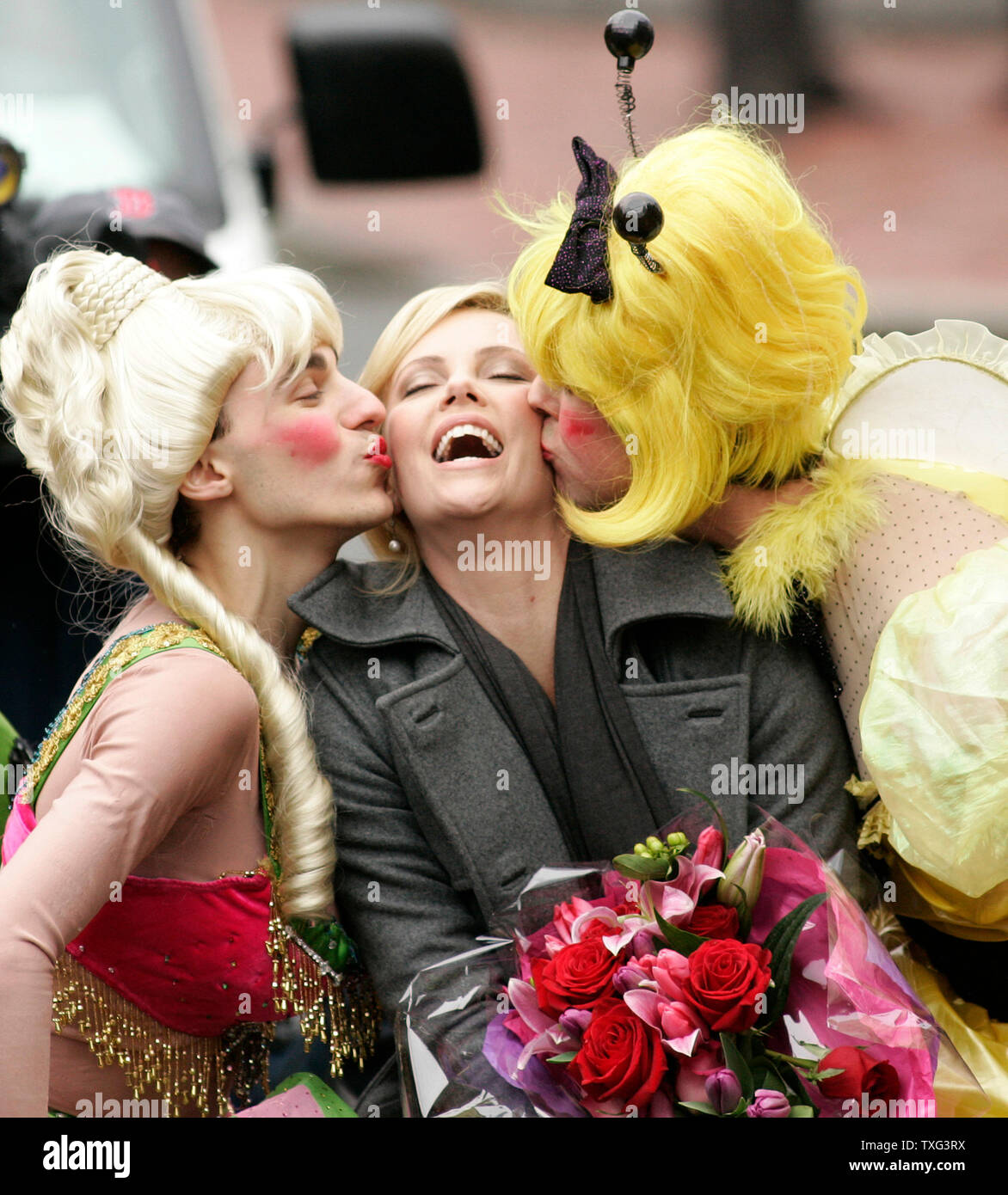 Actress Charlize Theron (C) receives a kiss from Harvard students ...