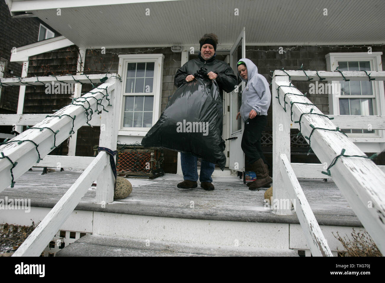 Glenn Arrigo (L) and daughter Brittany (R) carry belongings to their ...