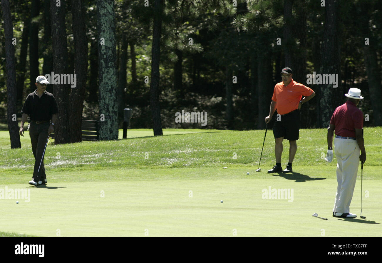 President Barack Obama (L) plays the first hole of the Farm Neck Golf ...