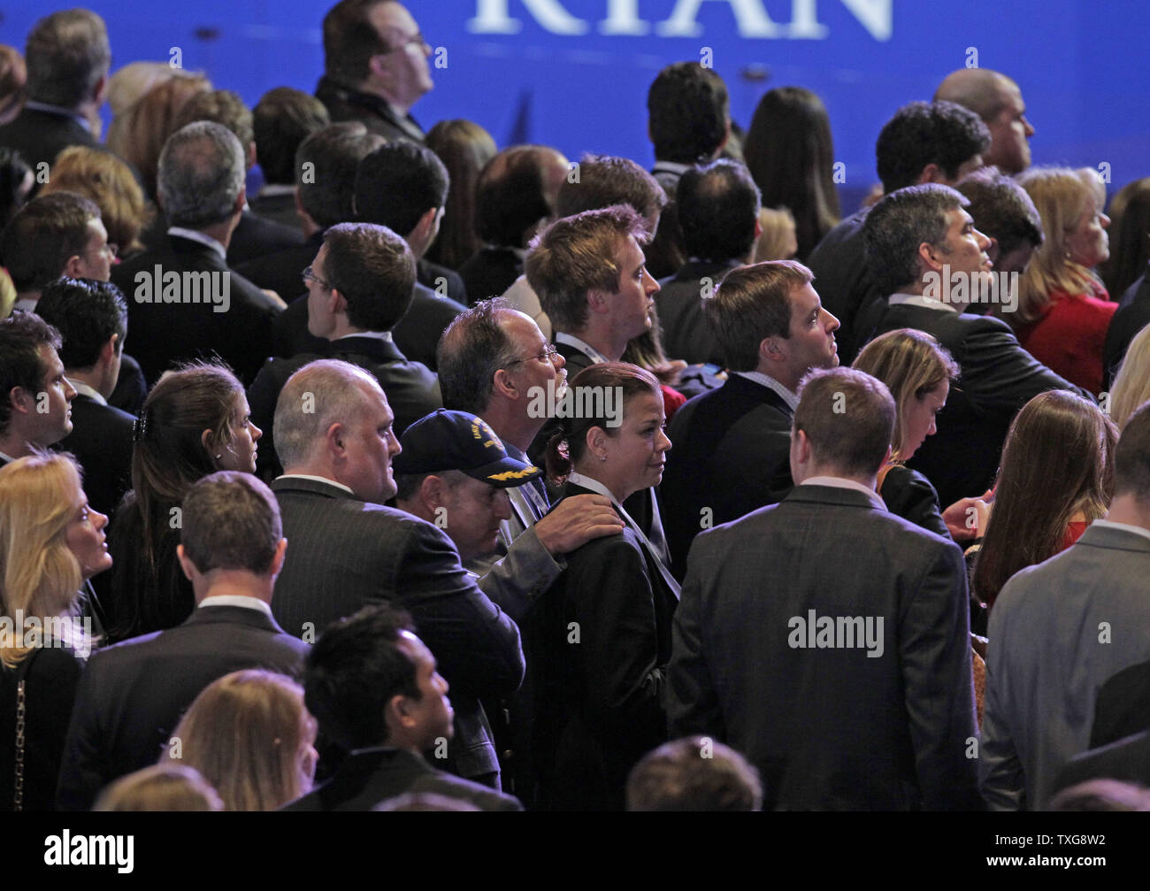 Solemn faced Romney supporters watch projections of the re-election of ...