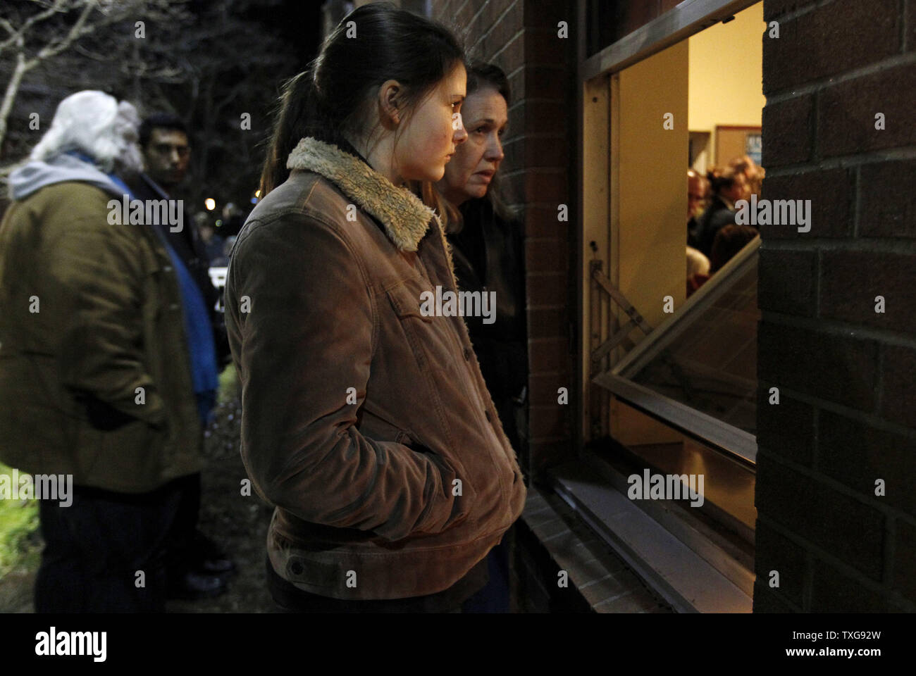 Liz Talbot (L) of Newtown, Connecticut and her mother Amy Talbot peek ...