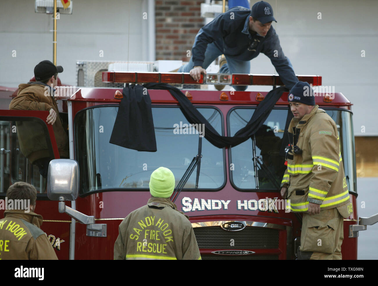 Fire fighters with the Sandy Hook Fire and Rescue drape black bunting ...