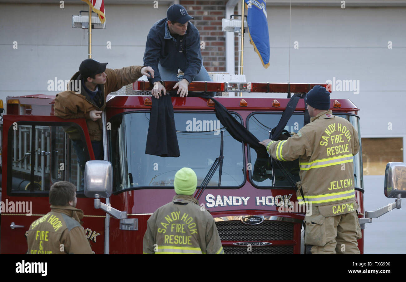 Fire fighters with the Sandy Hook Fire and Rescue drape black bunting ...