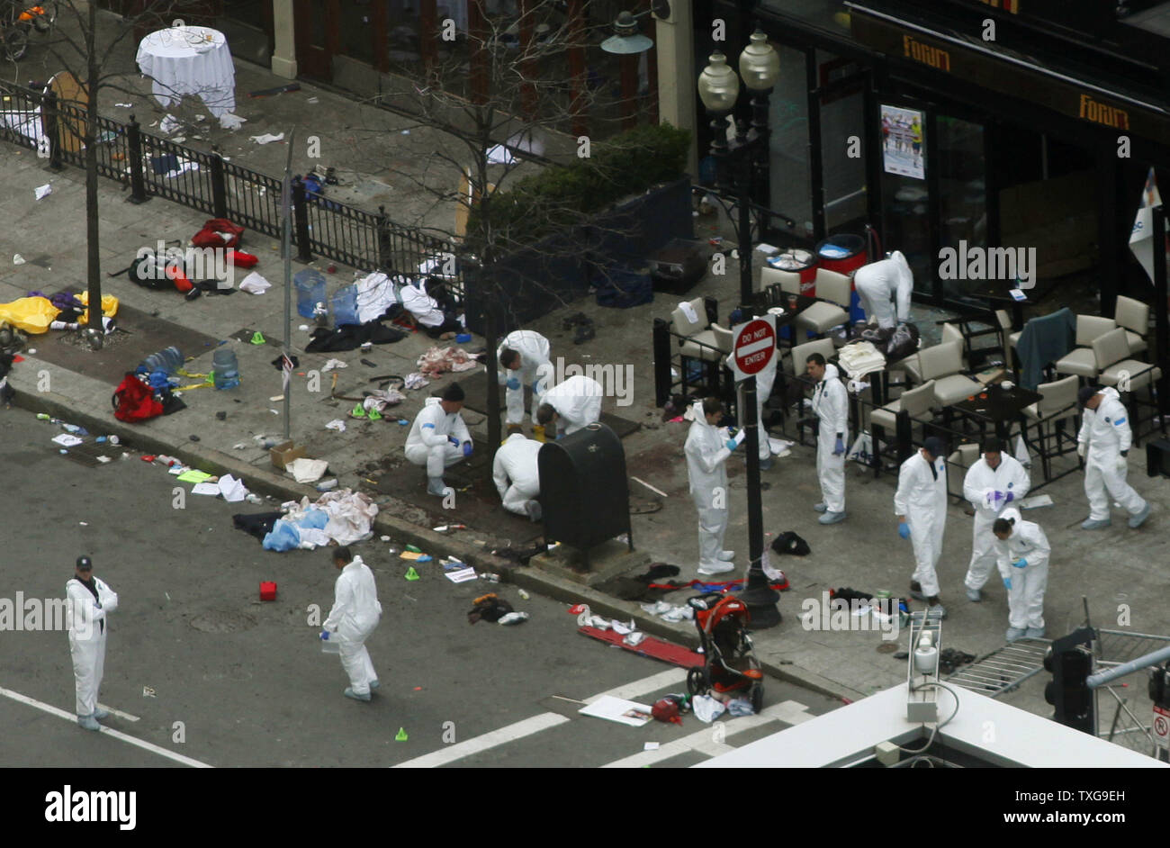Crime scene investigators dig through the scene of a bombing on ...