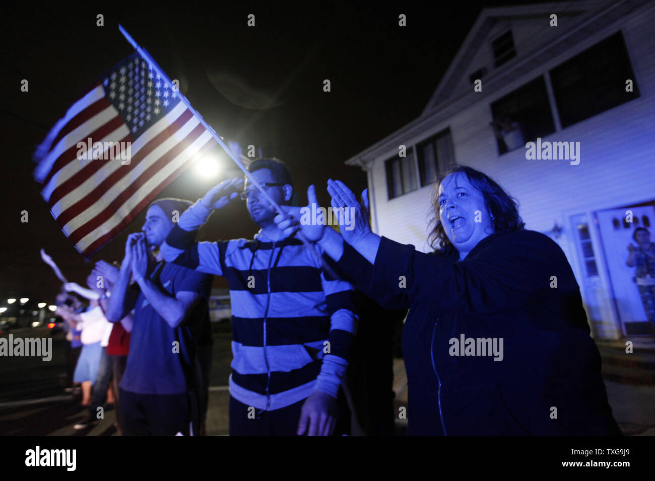 Barbara Faherty waves an American flag and cheers on the police with ...