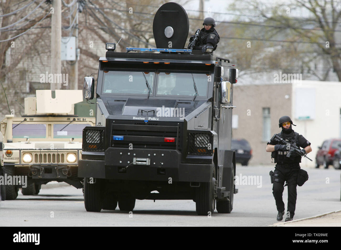 SWAT team members walk up School Street in Watertown, Massachusetts ...