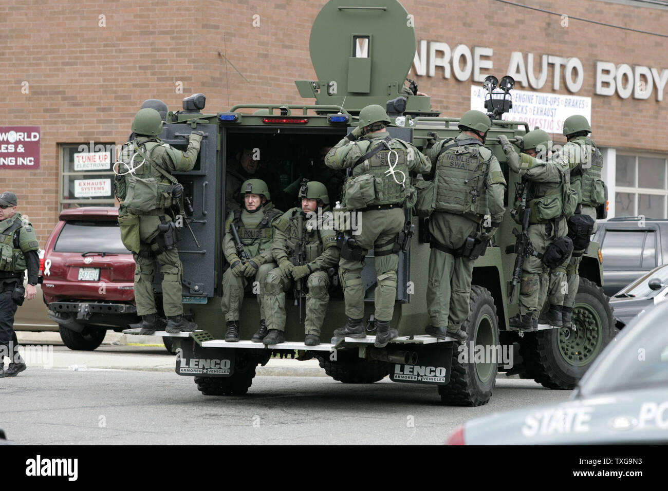 SWAT team members are driven down School Street in Watertown ...