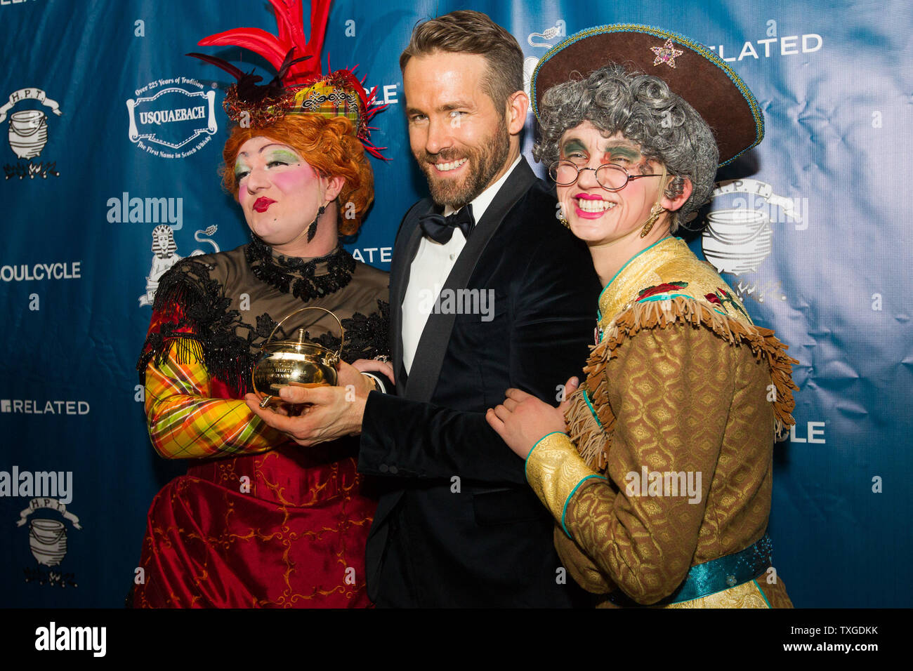 Actor Ryan Reynolds (C) poses with his Pudding Pot trophy with Harvard ...