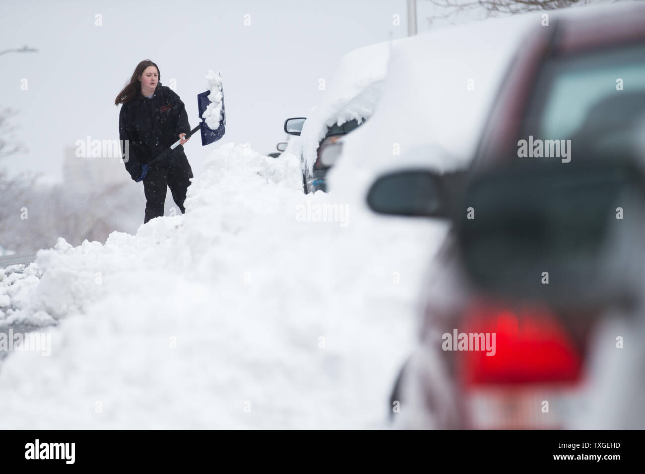 A woman shovels out her car in Worcester, Massachusetts on March 8, 2018. A nor'easter hit the ...