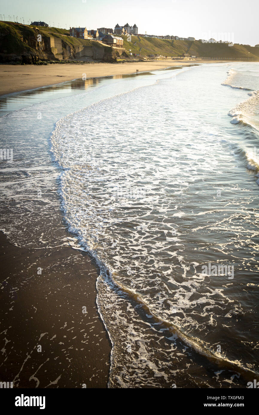 WHITBY in ENGLAND. People walking on Whitby beach on a fine sunny ...