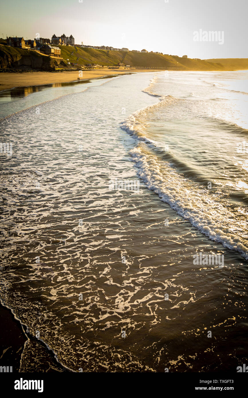 WHITBY in ENGLAND. People walking on Whitby beach on a fine sunny ...